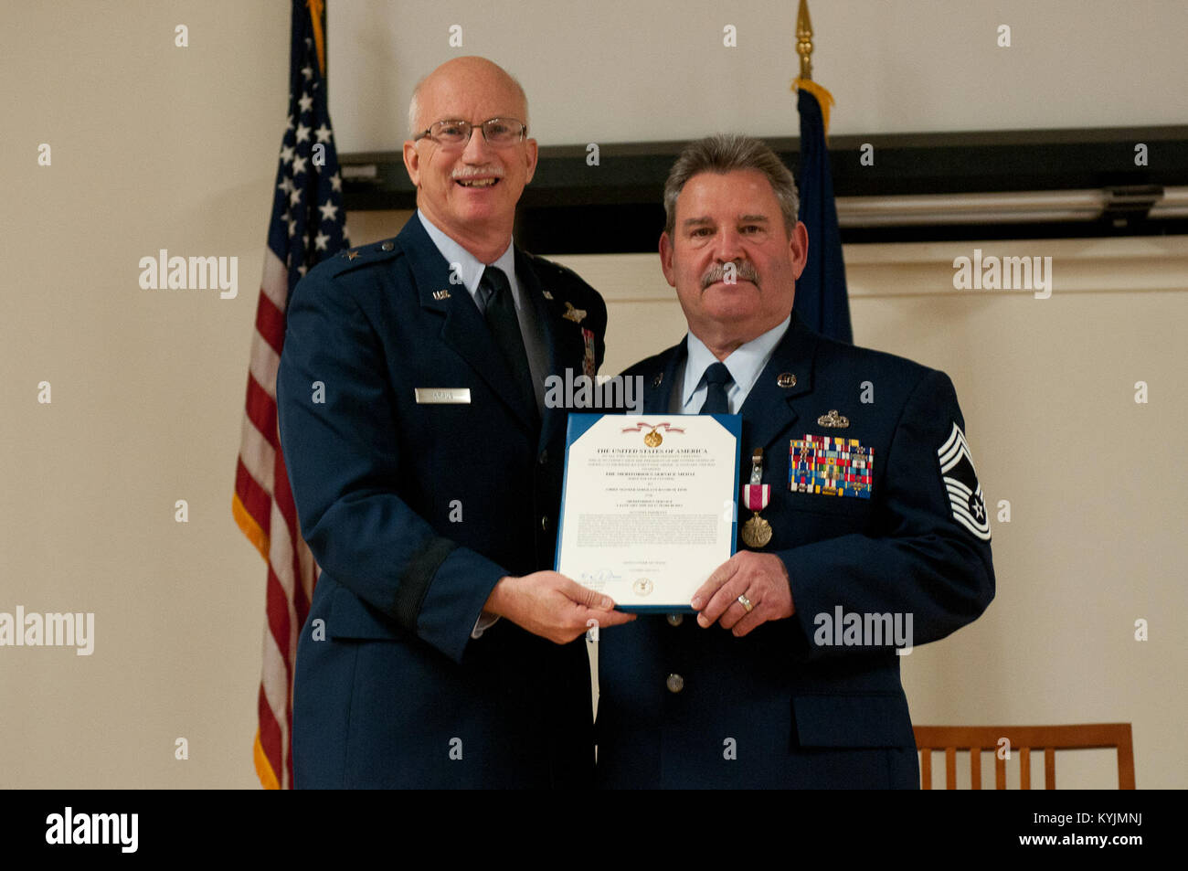 Chief Master Sgt. David Fink (right) is presented with a Meritorious ...