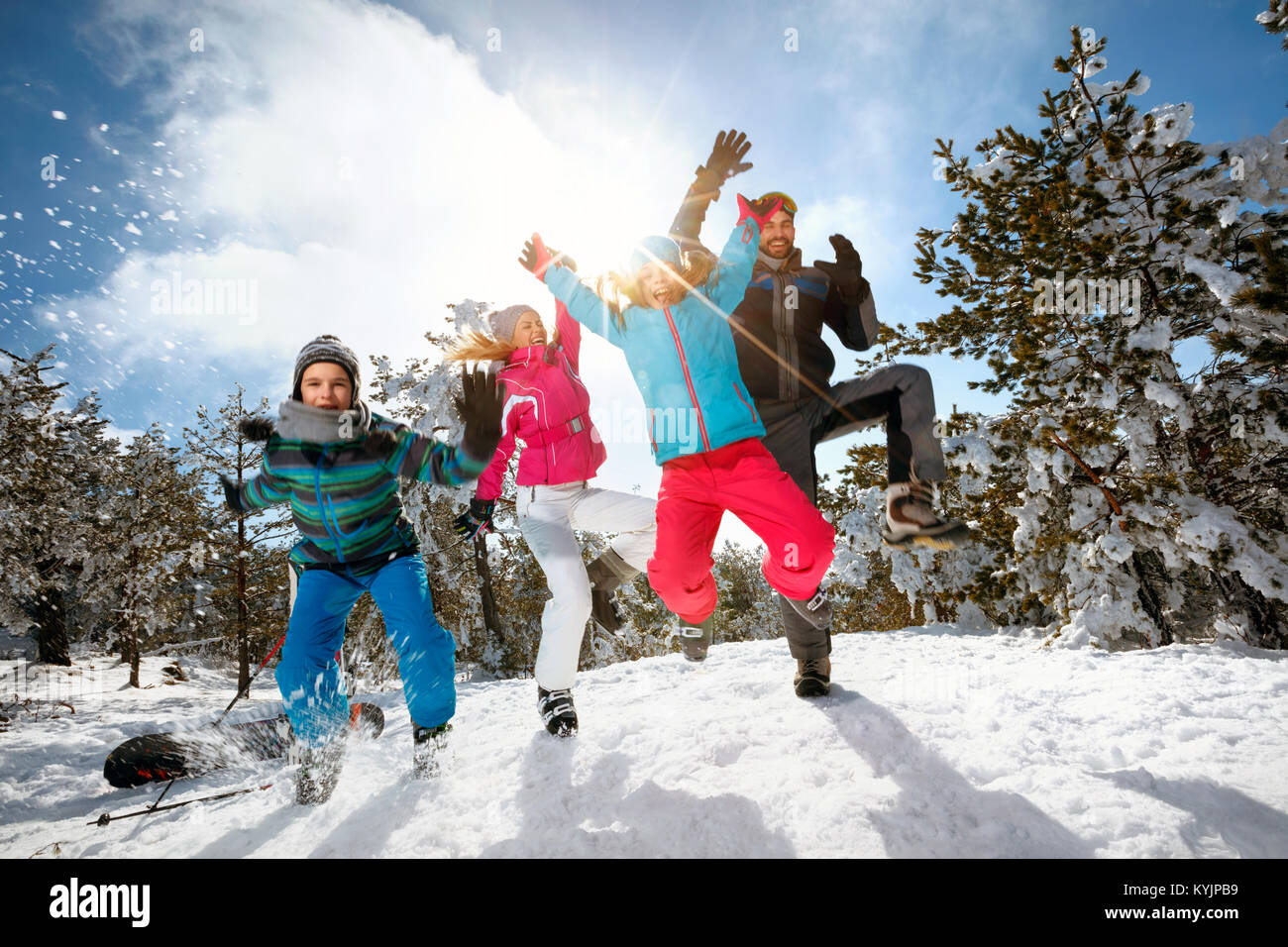 Happy family with children high jump on winter day on ski vacation and ...