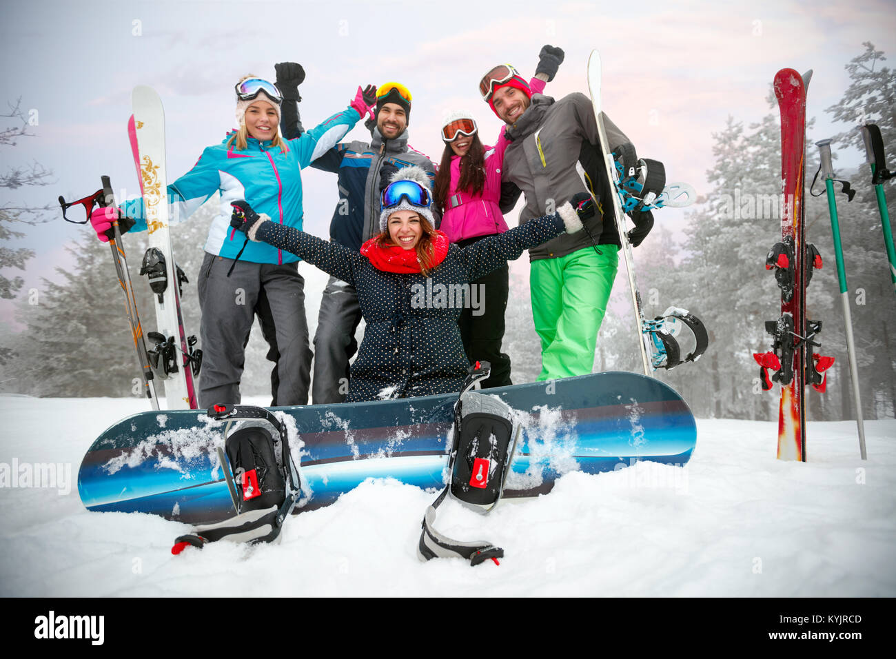 Group of happy friends snowboarders and skiers have fun on the slope ...