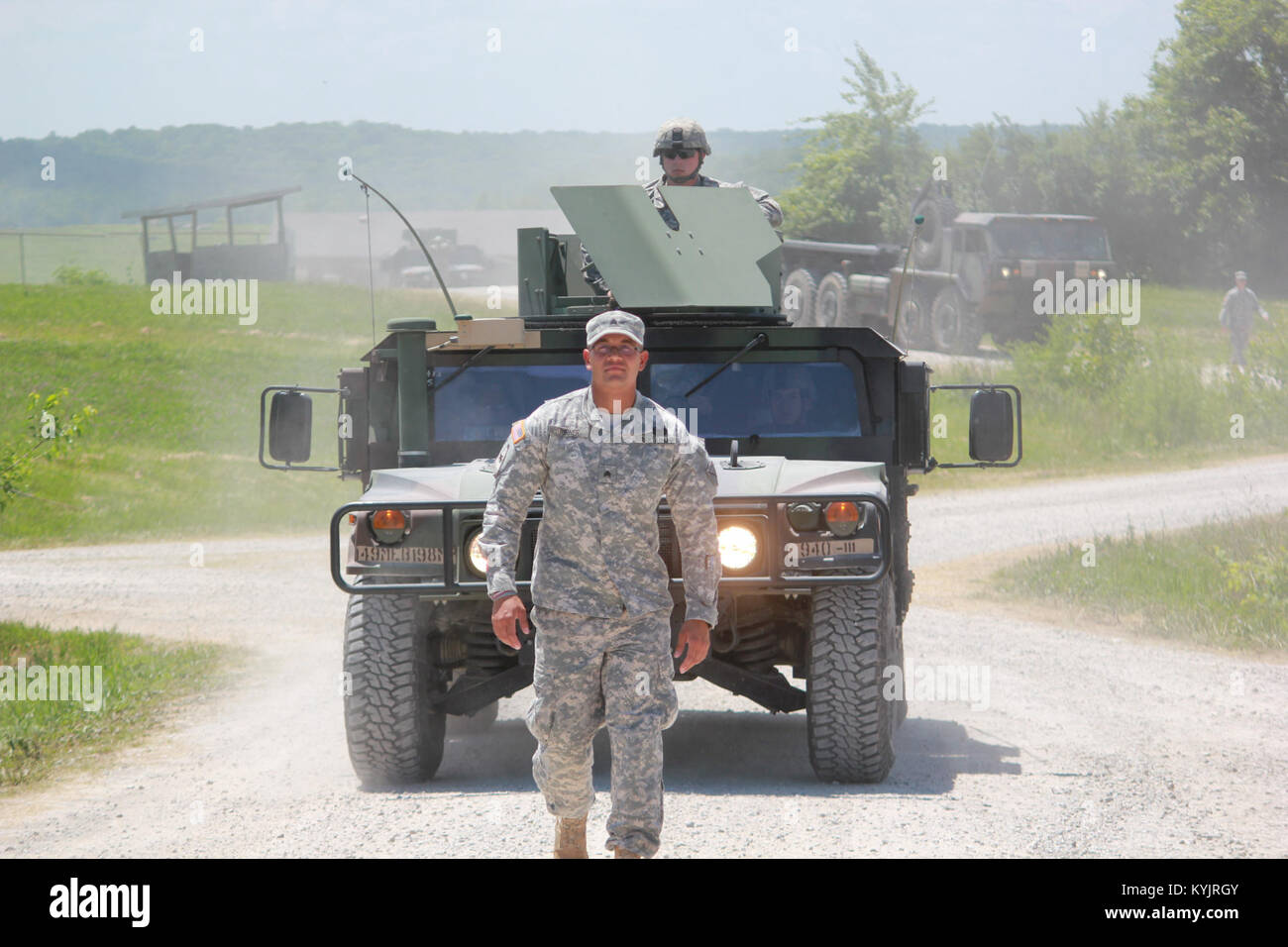 Sgt. Terrell Turner ground guides a scout vehicle back in a training ...