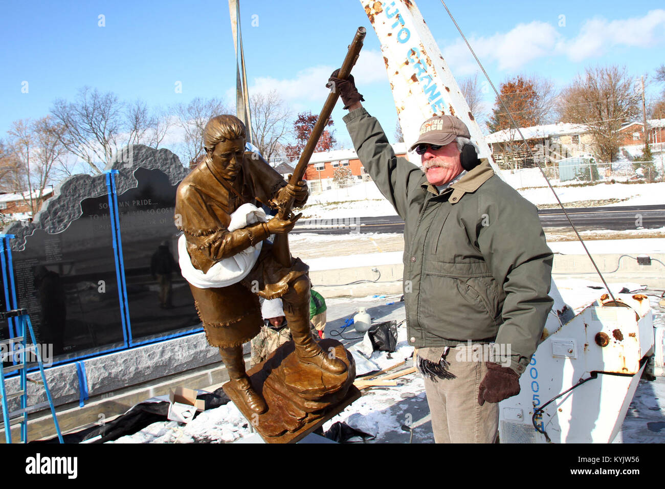 Wyatt Gragg guides a newly bronzed statue of Daniel Boone into position ...