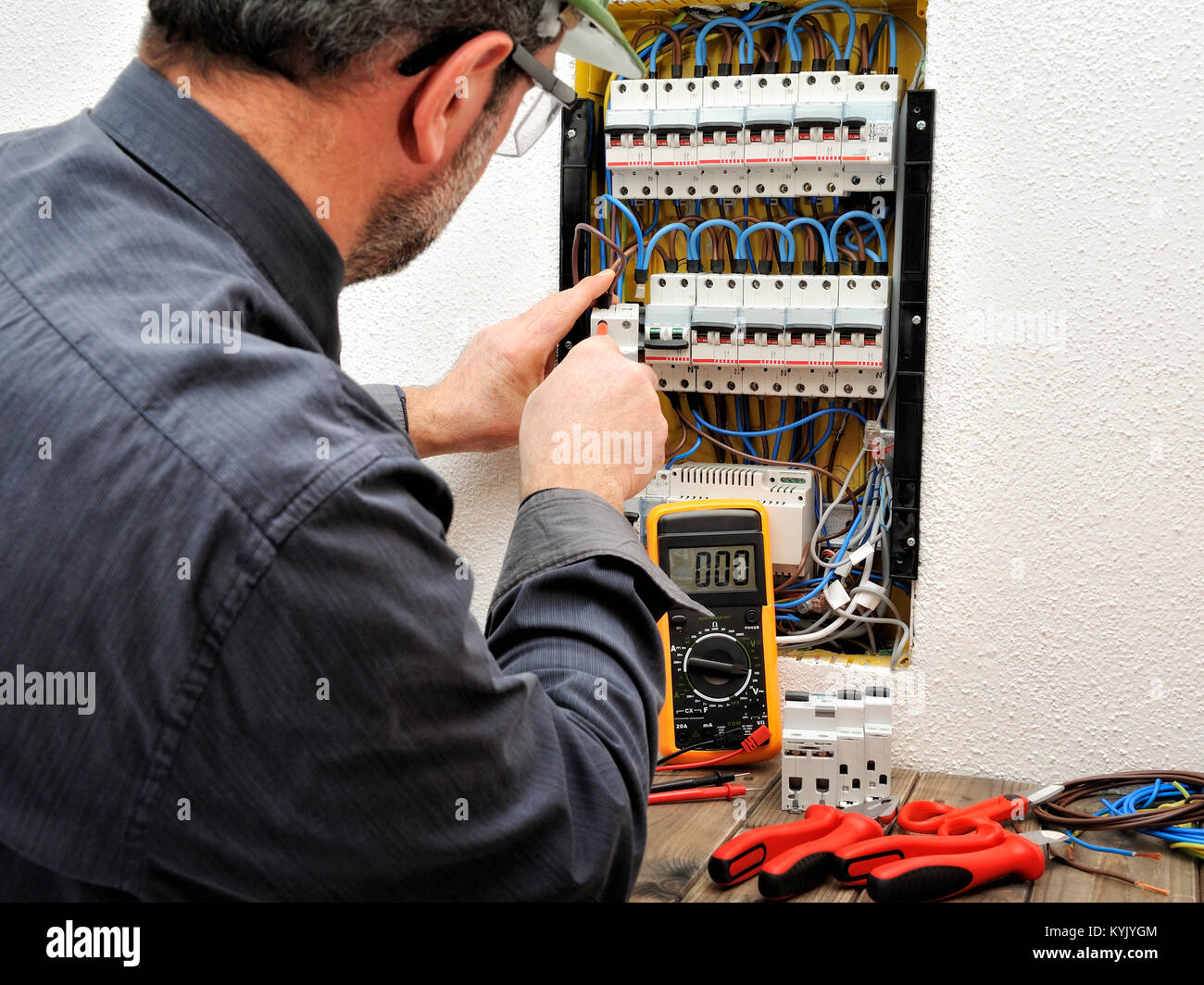 Technical electrician fixing the cable into the terminal of a circuit ...