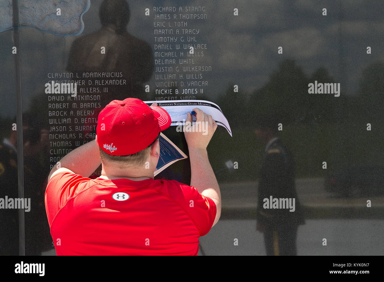 A visitor to the Kentucky National Guard Memorial traces a nameon the ...