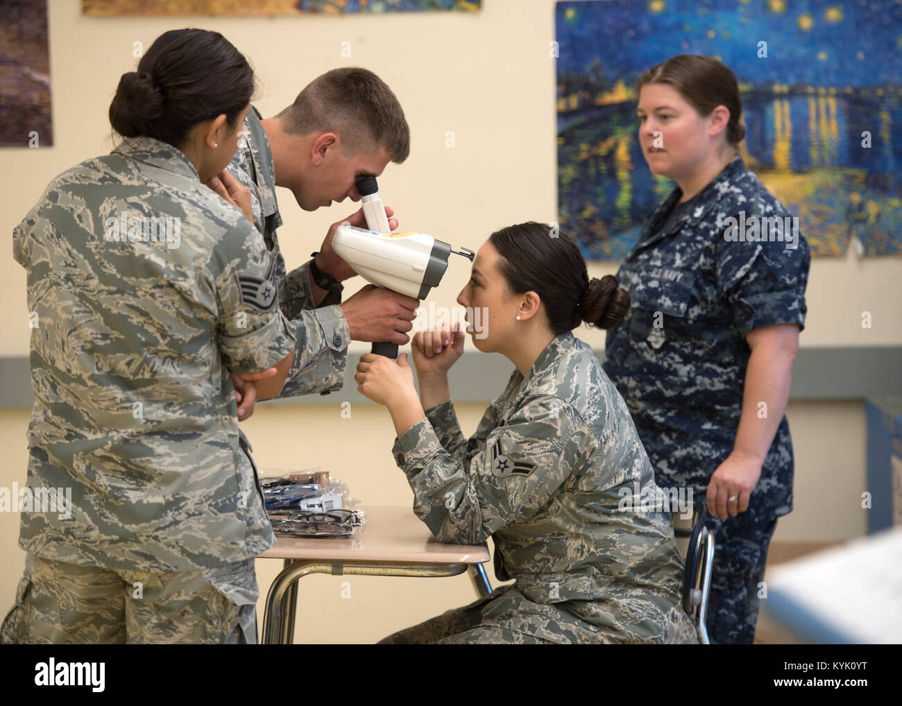 U.S. Air Force Airmen and a U.S. Navy Sailor test optometry equipment ...