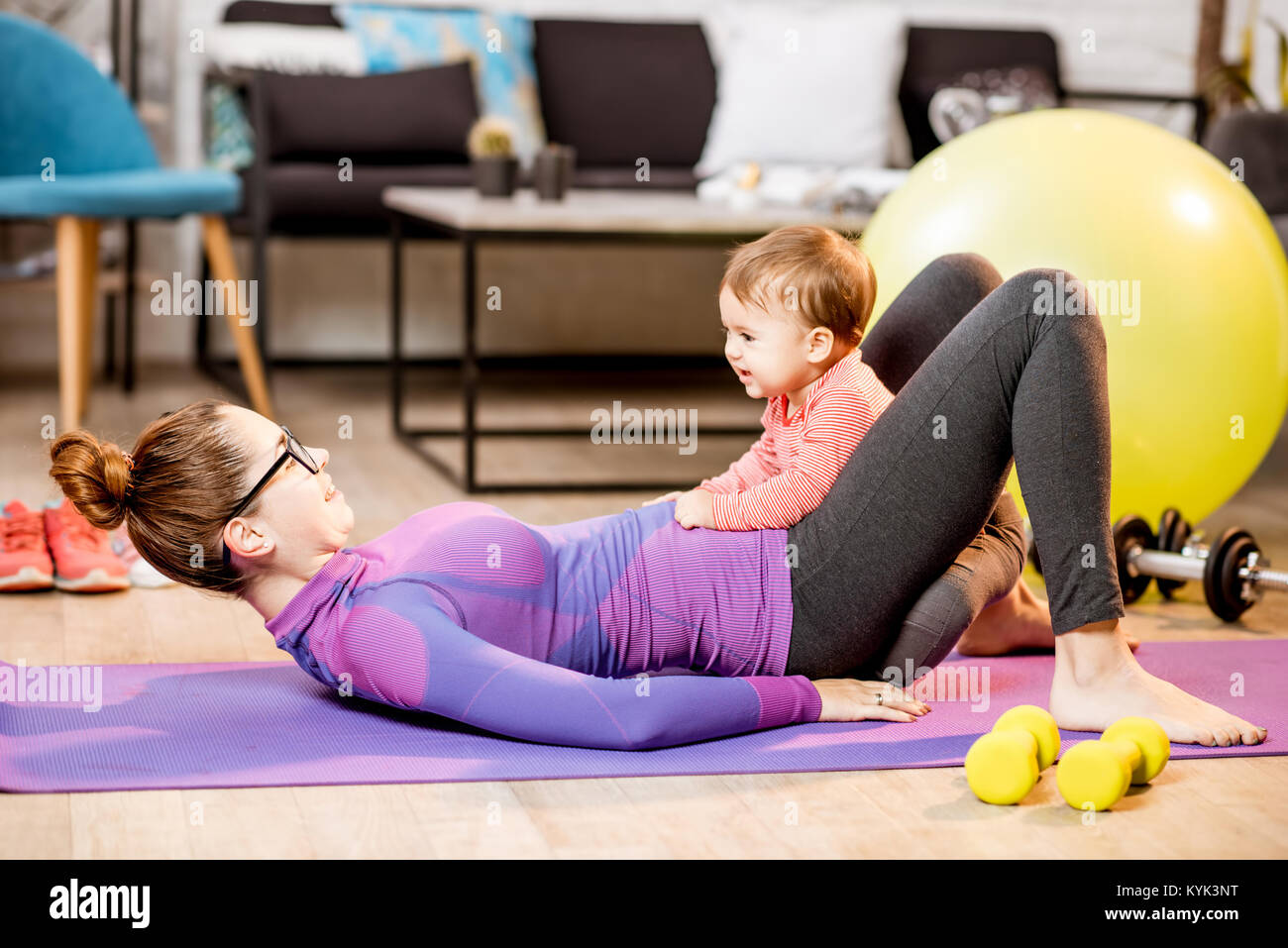 Mother exercising with her baby son at home Stock Photo - Alamy