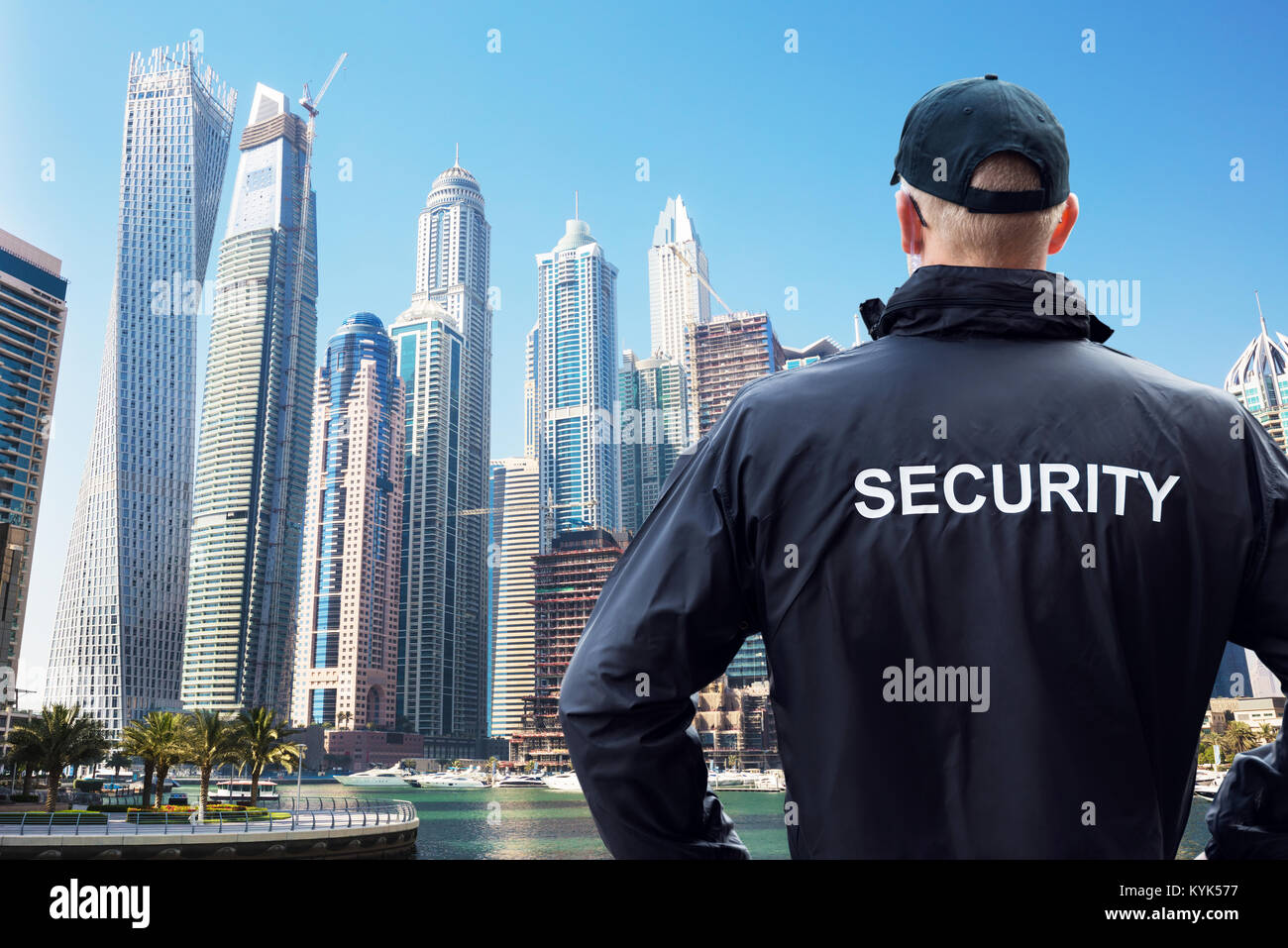 Rear View Of Male Security Guard Looking At City Skyline Stock Photo ...