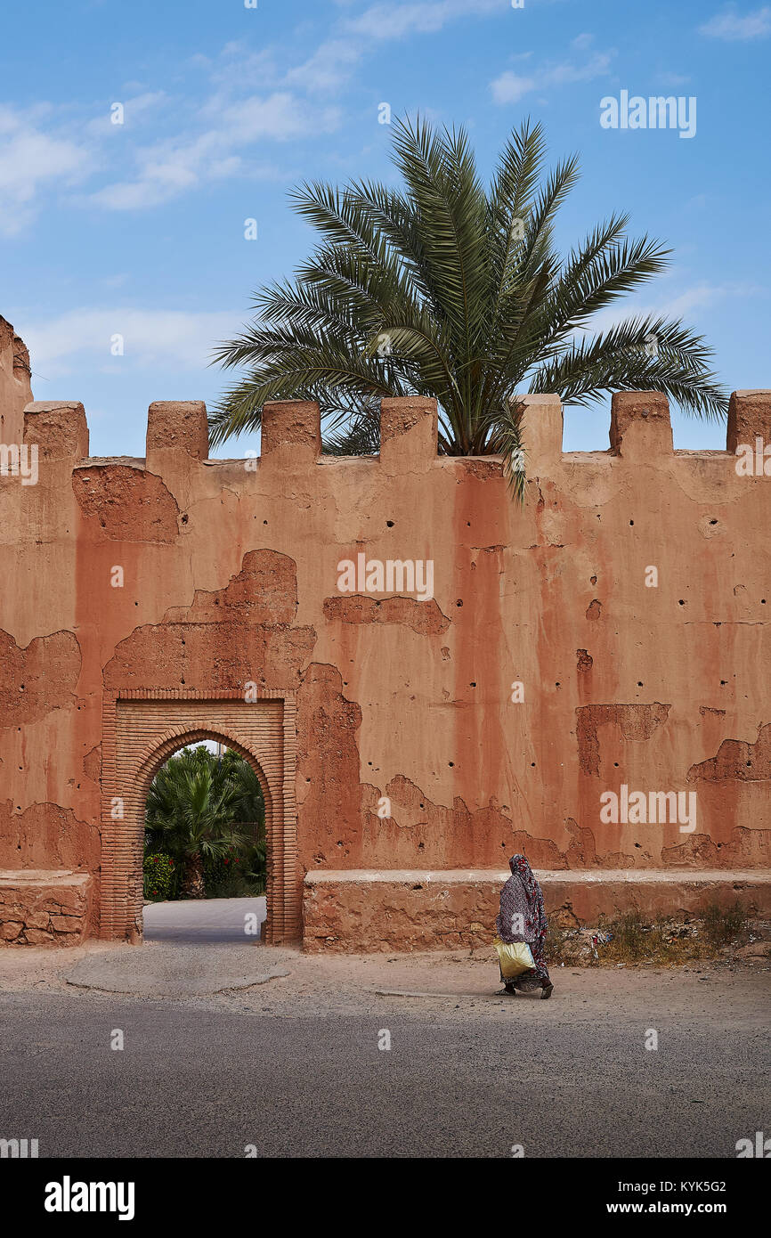 Morrocan veiled woman walking to fortification door, Taroudant, Morocco ...
