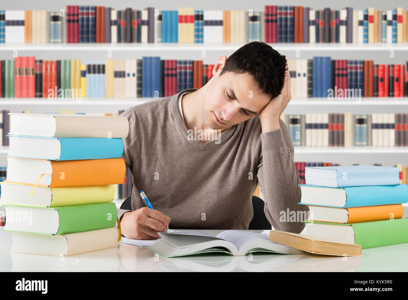 Stressful University Student Studying In Front Of Bookshelf At Library ...