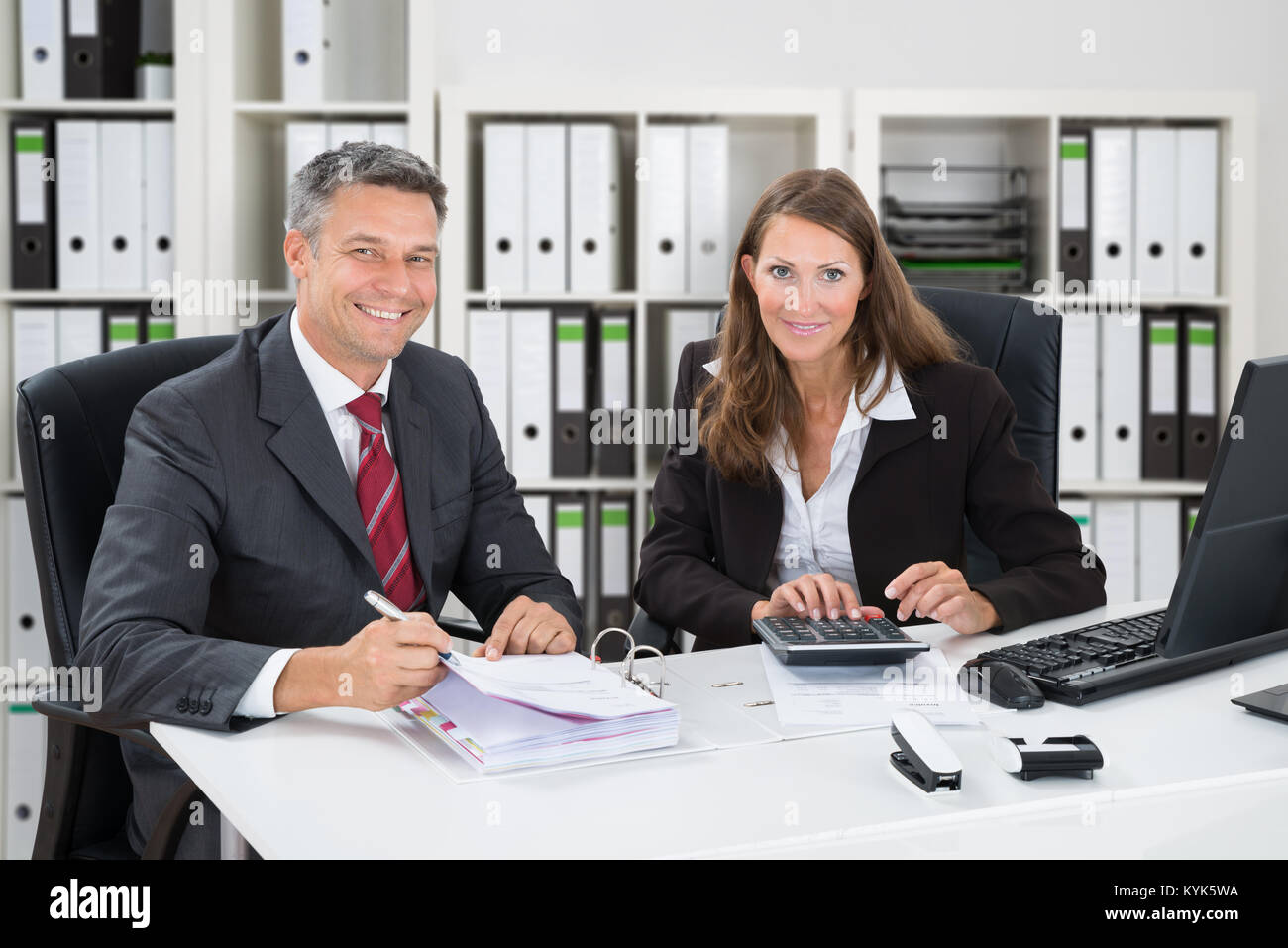 Portrait Of Smiling Accountant Calculating Taxes In Office Stock Photo ...