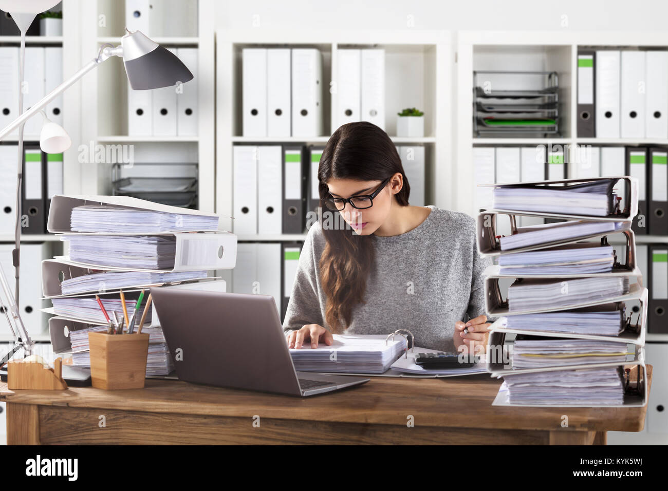 Young Businesswoman Wearing Eyeglasses Calculating Bill In Office Stock ...