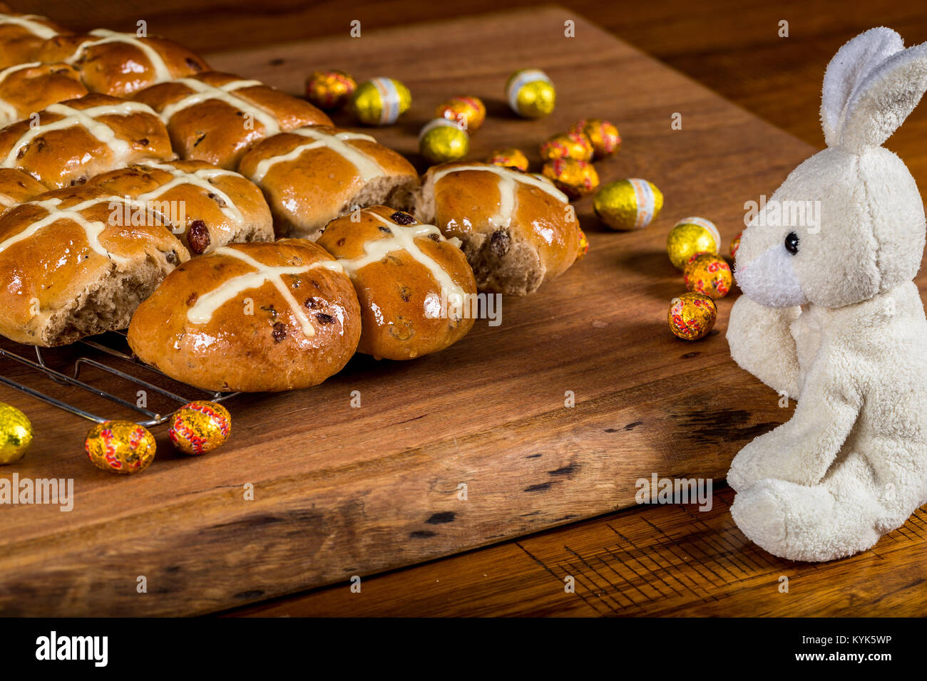 Fresh baked hot cross buns with plush toy rabbit and Easter Eggs Stock ...