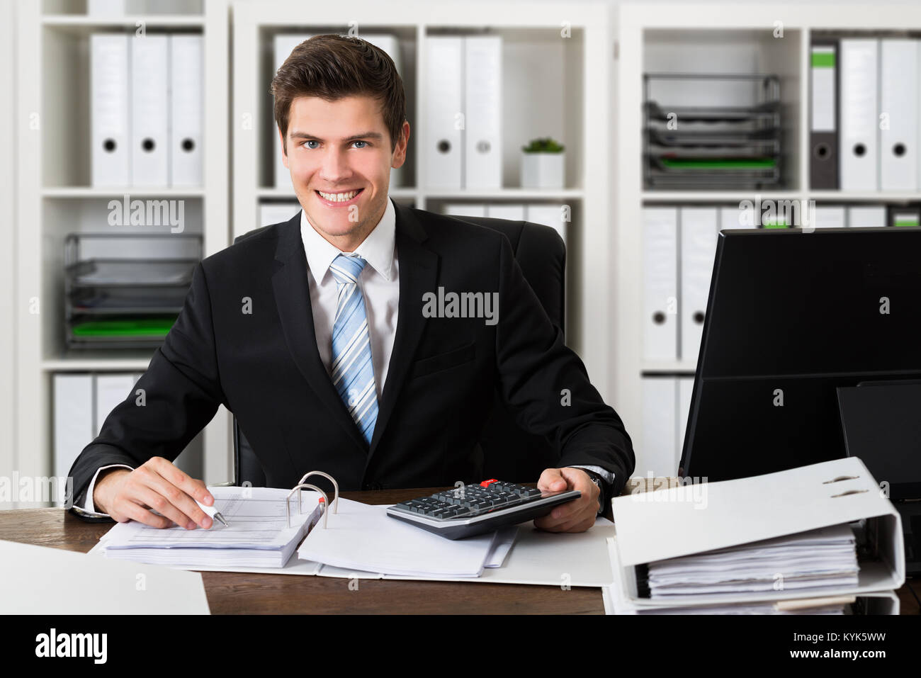 Portrait Of A Happy Young Accountant Calculating Invoice Stock Photo ...