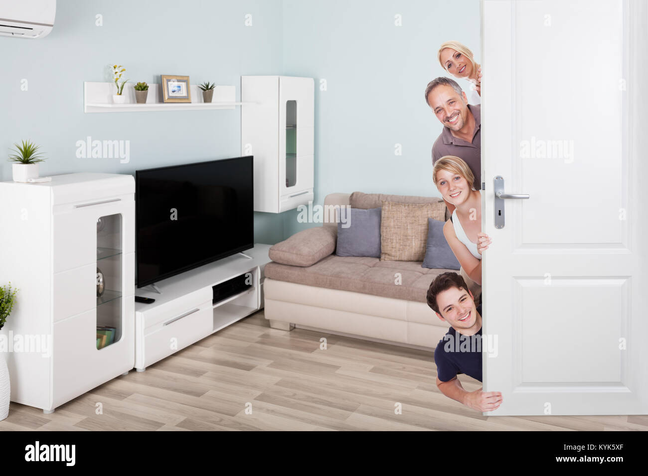 Portrait Of Happy Family Peeking From Door In Living Room Stock Photo ...