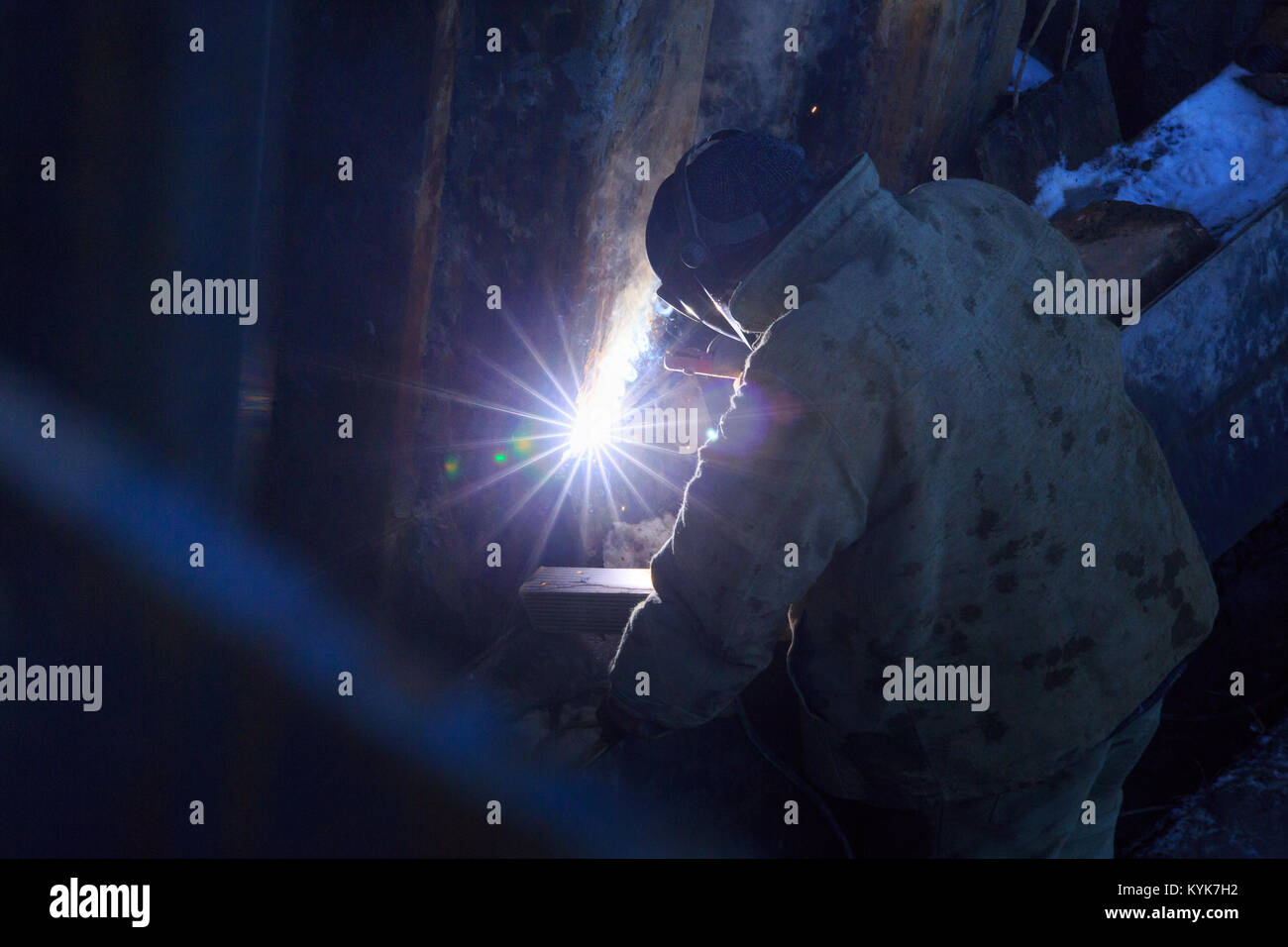 Welder from the back, in backlight from electric welding Stock Photo ...