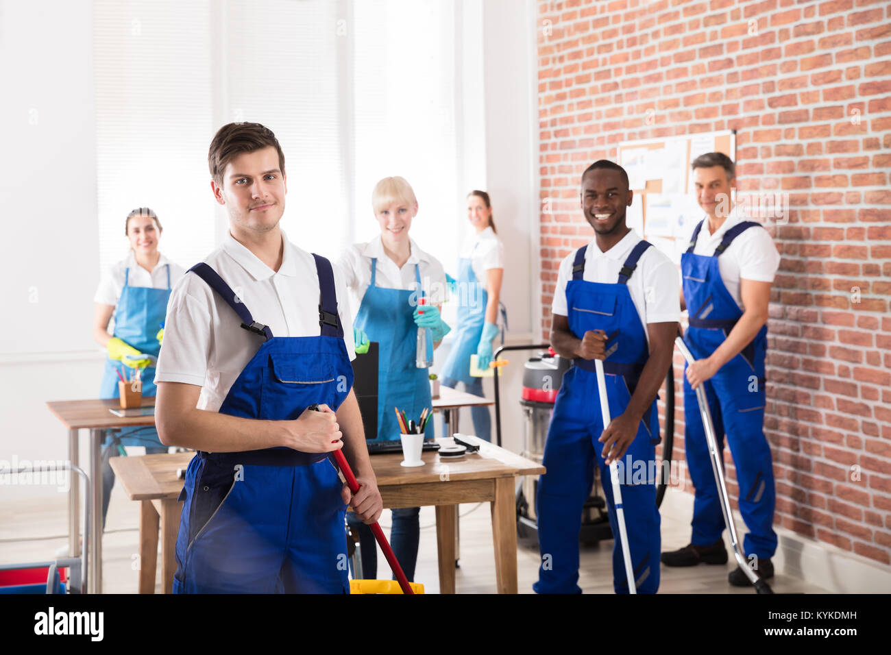 Group Of Diverse Janitors In Uniform Cleaning The Office With Cleaning ...