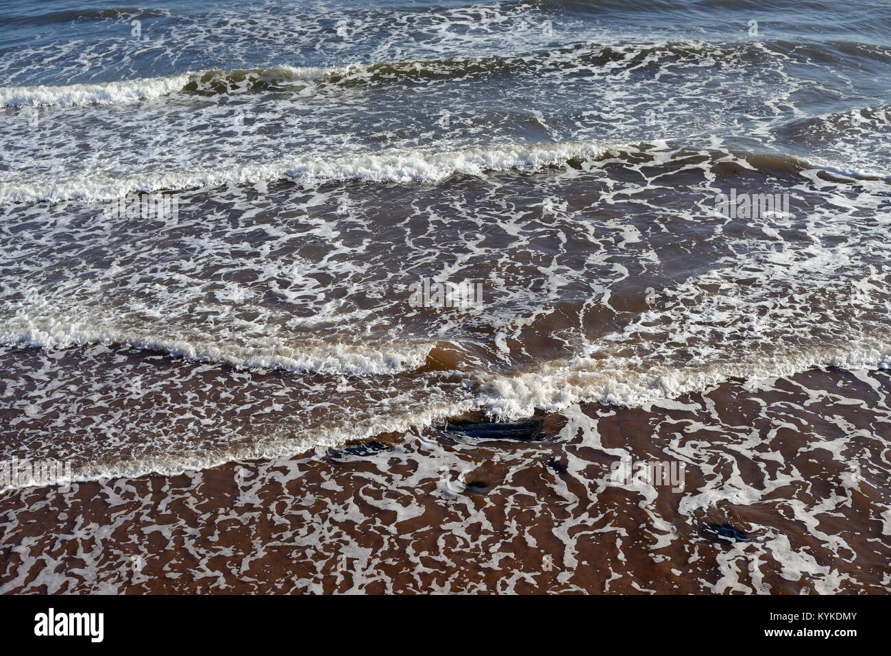 Shallow waves flowing across the beach Stock Photo - Alamy
