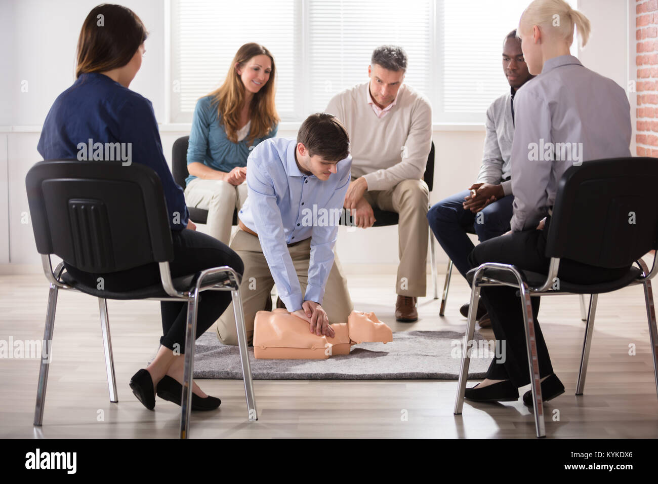 Young Male Instructor Showing CPR Training On Dummy To His Student ...