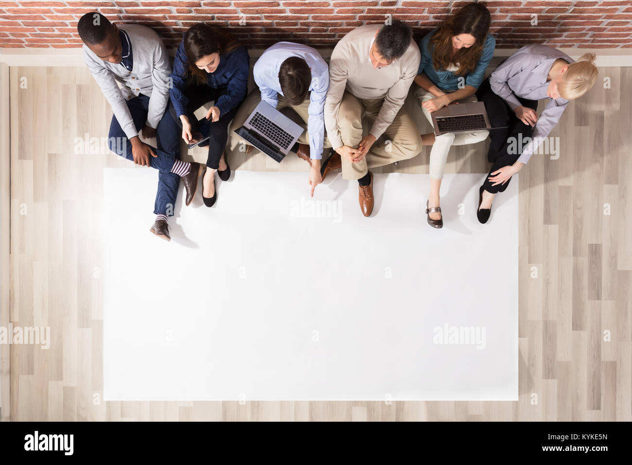Overhead View Of Diverse People Sitting On Hardwood Floor Looking At ...