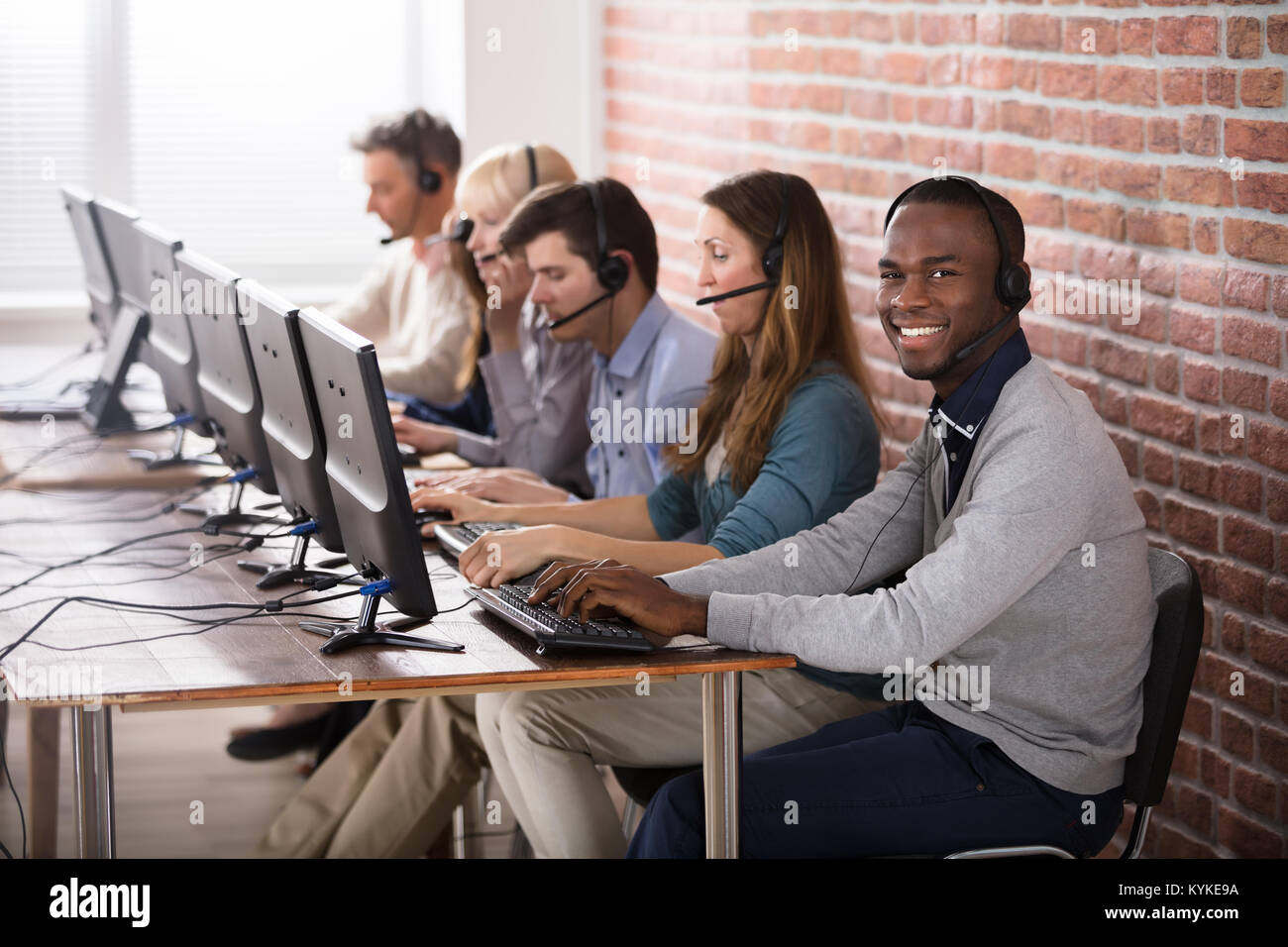 Young Call Center Team Talking With Customers Stock Photo - Alamy
