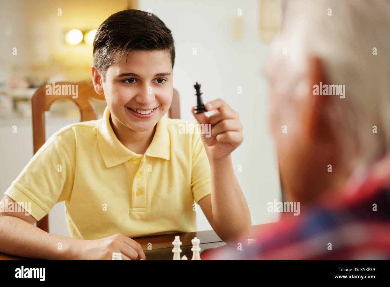 Grandpa Playing Chess Board Game With Grandson At Home Stock Photo - Alamy
