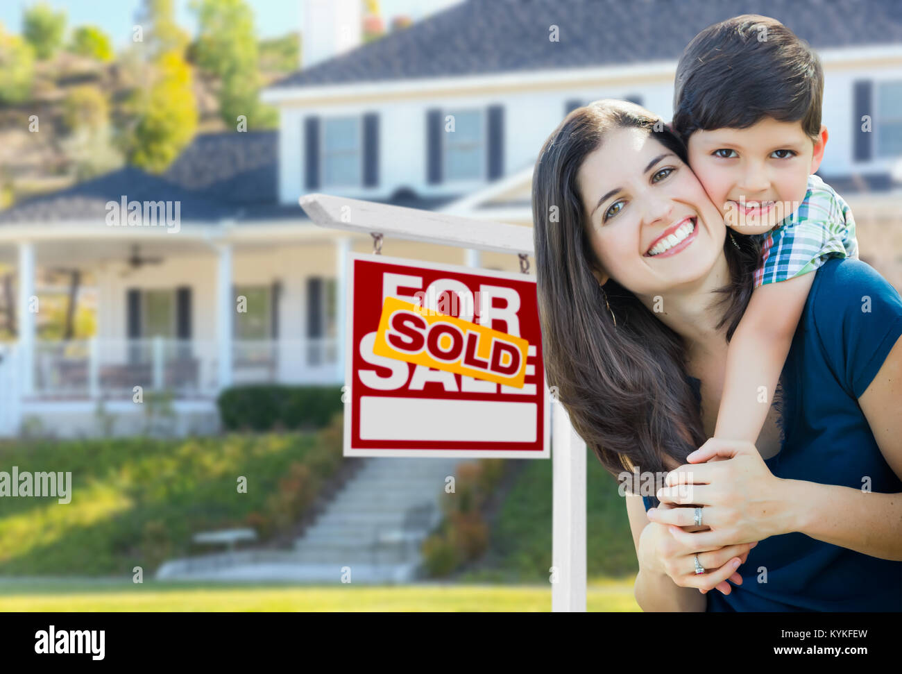 Young Mother and Son In Front of Sold For Sale Real Estate Sign and ...