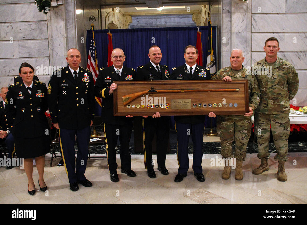 Chief Warrant Officer Dean Stoops is presented a token of appreciation ...