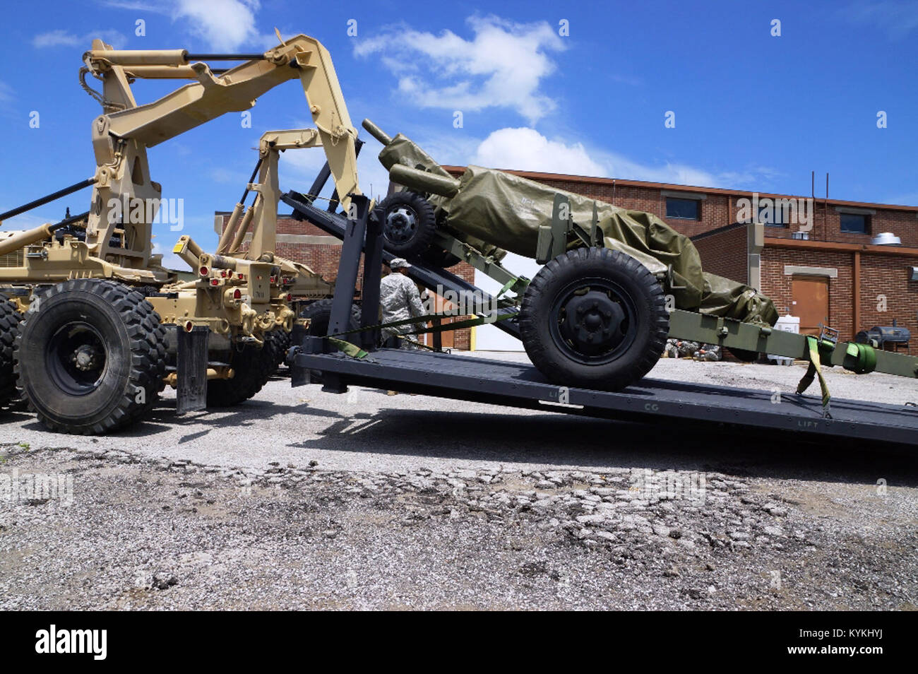 Two105 millimeter howitzer canons are lowered an Army Load Handling ...