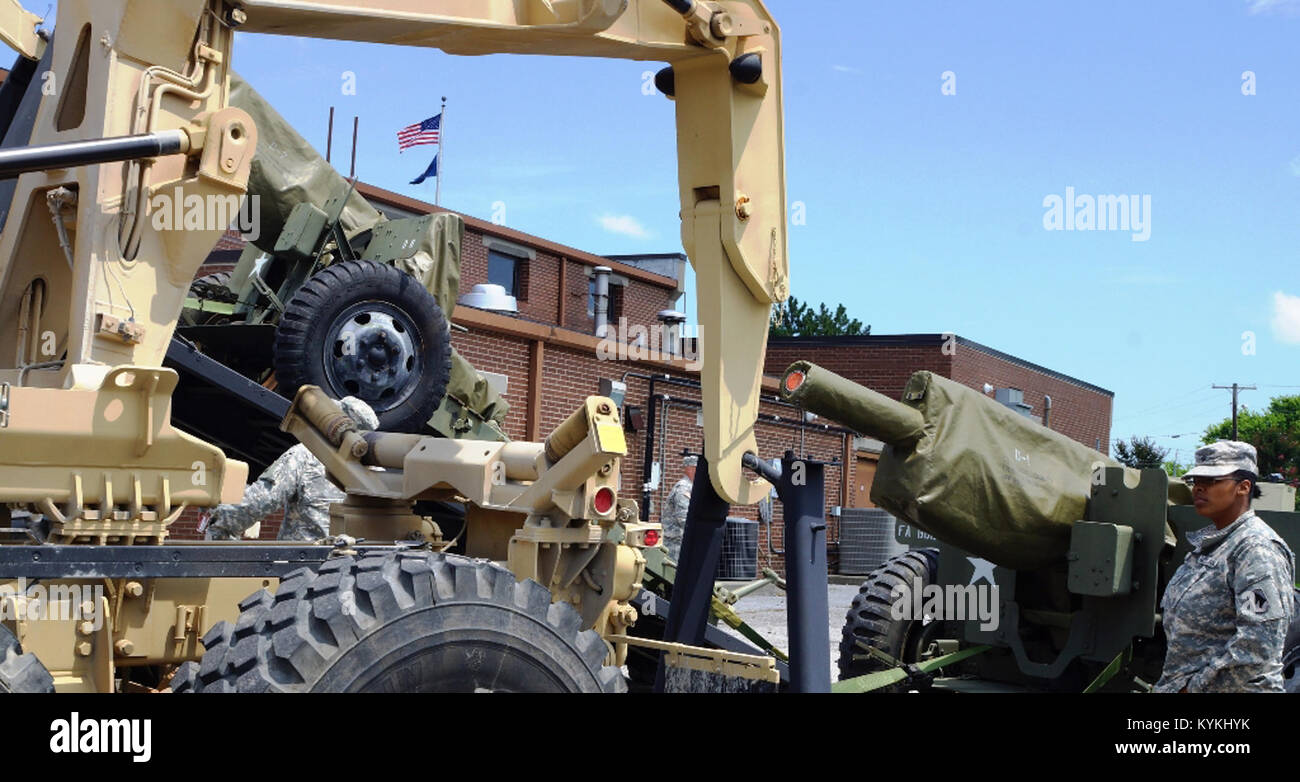 Two105 millimeter howitzer canons are lowered an Army Load Handling ...