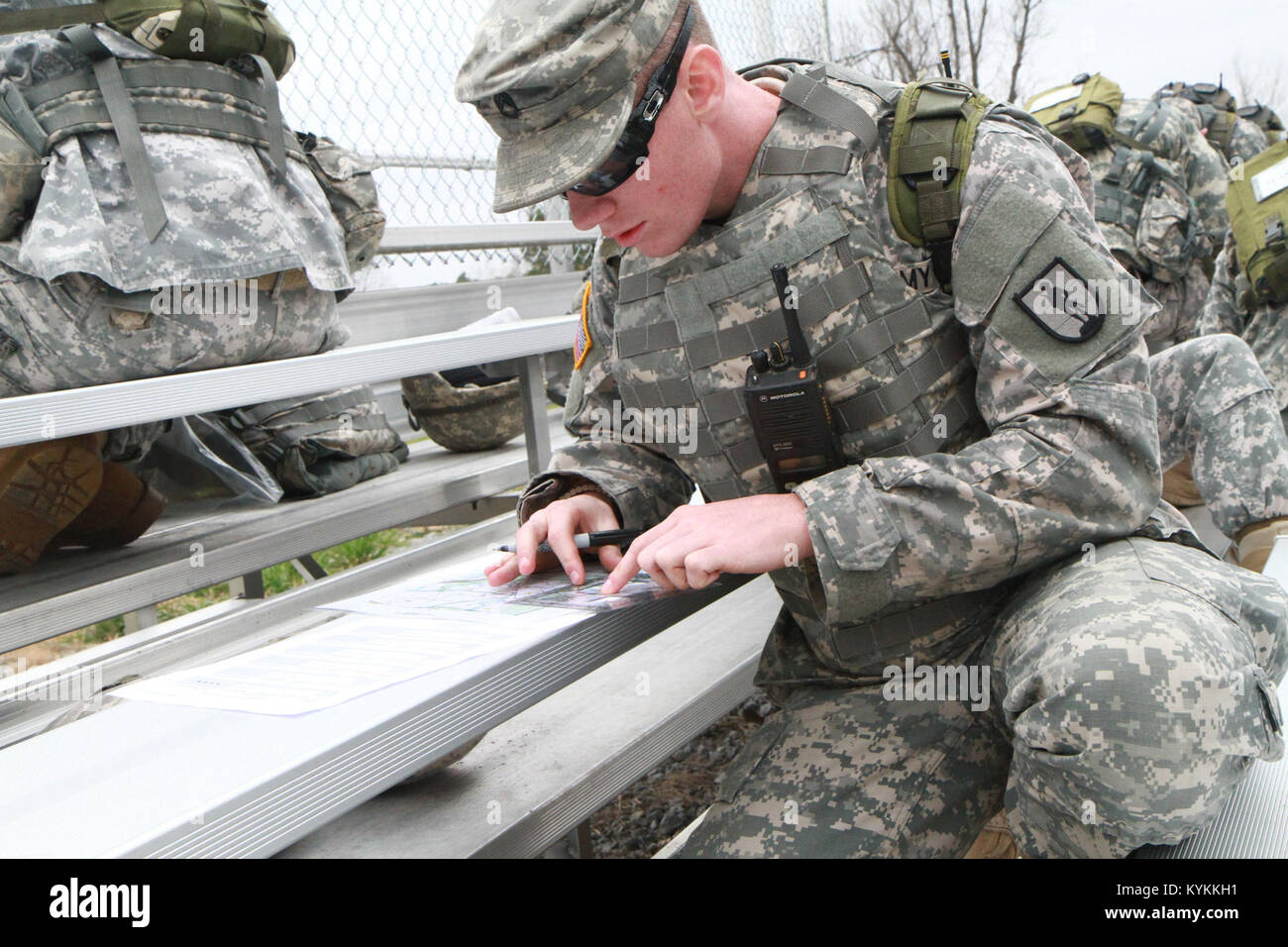 Staff Sgt. Aaron Cundiff with the 238th Regiment plots points on a maps ...