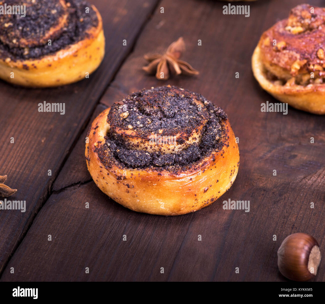 round poppy and nut buns on a brown wooden table, close up Stock Photo ...