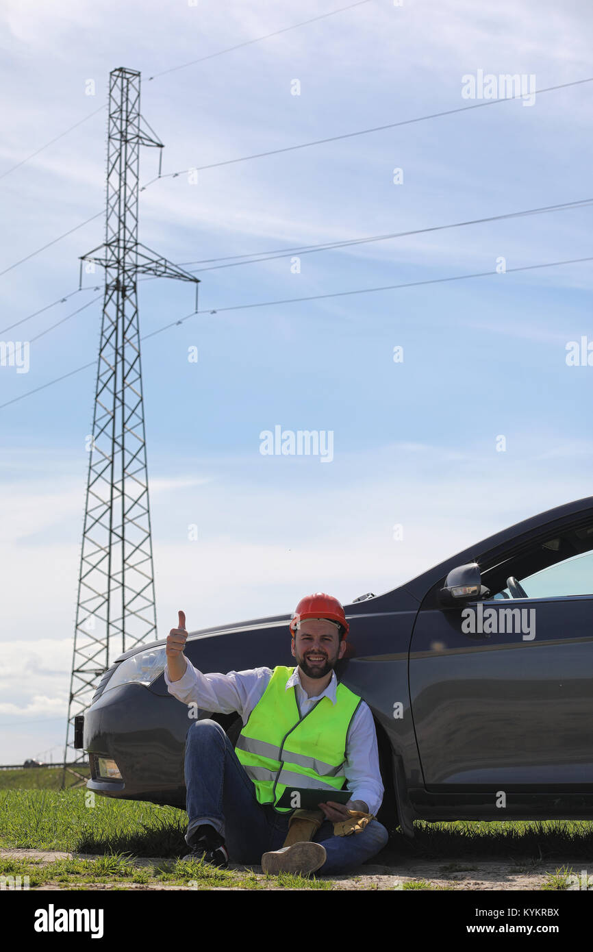 An electrician in the fields near the power transmission line. T Stock ...