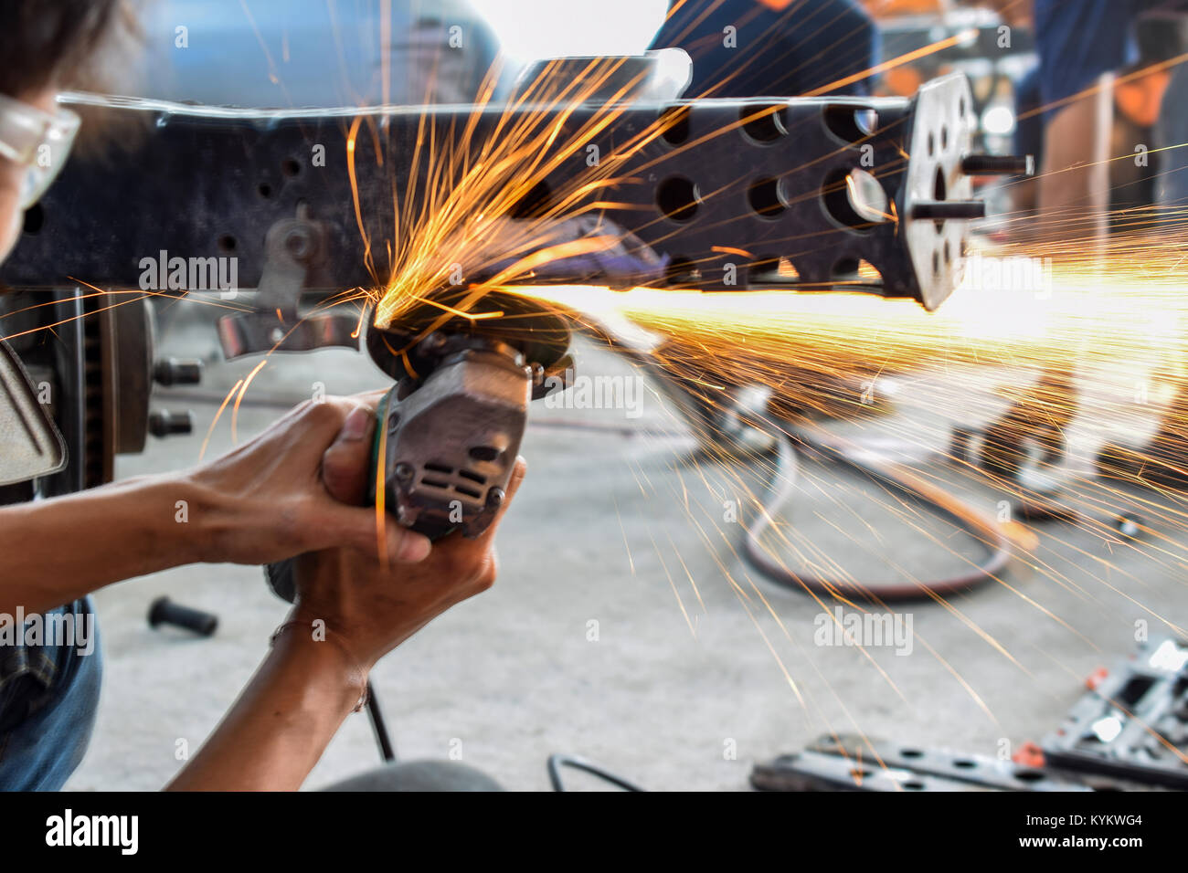 Electric wheel grinding on chassis of a car - auto body repair shop ...