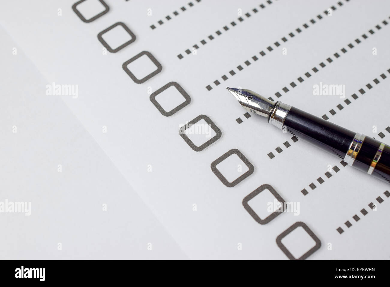 Check boxes on white paper with pen - closeup Stock Photo - Alamy