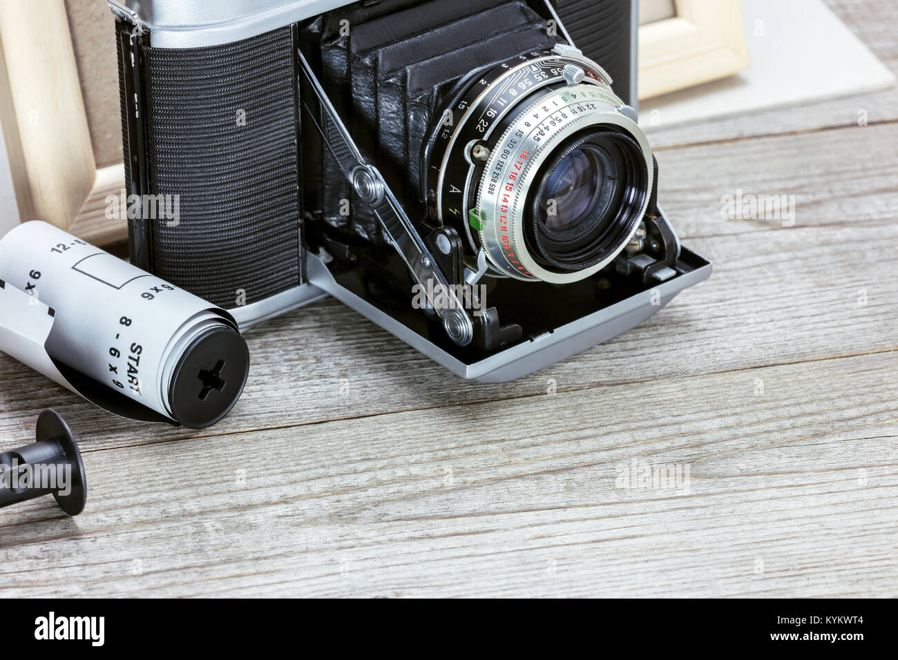 old retro camera, negative films and photo frame on wooden boards ...