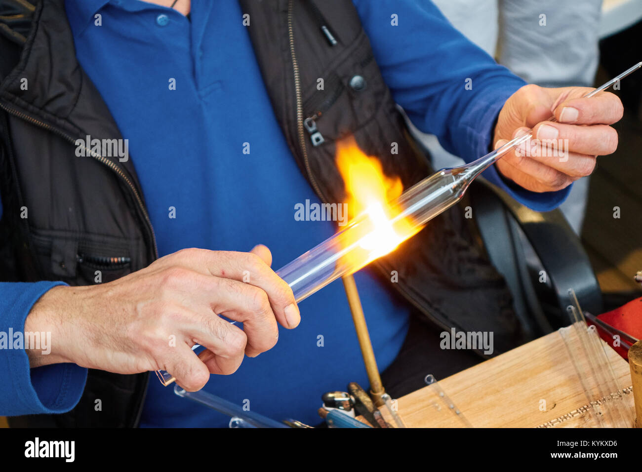 Glass master hands heat up the glass rod Stock Photo - Alamy