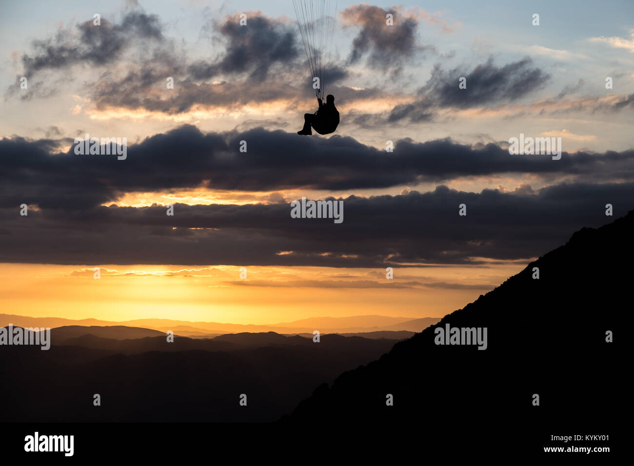 Beautiful shot of a paraglider silhouette flying over Monte Cucco ...