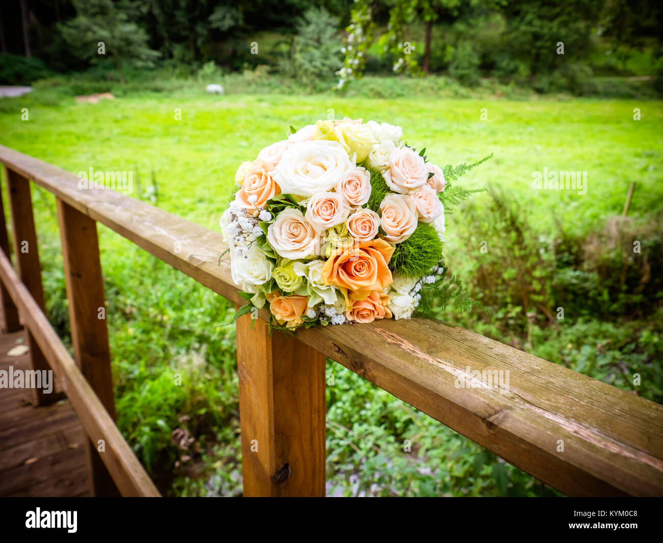 The bridal bouquet on the bridge with pink and orange roses Stock Photo ...