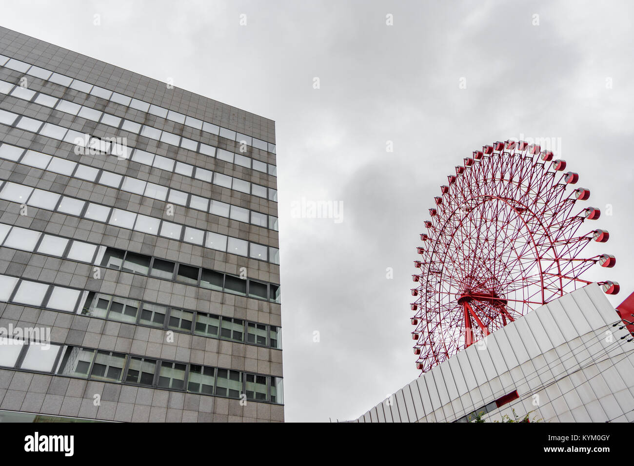 Red ferris wheel and office building against gray sky Stock Photo - Alamy
