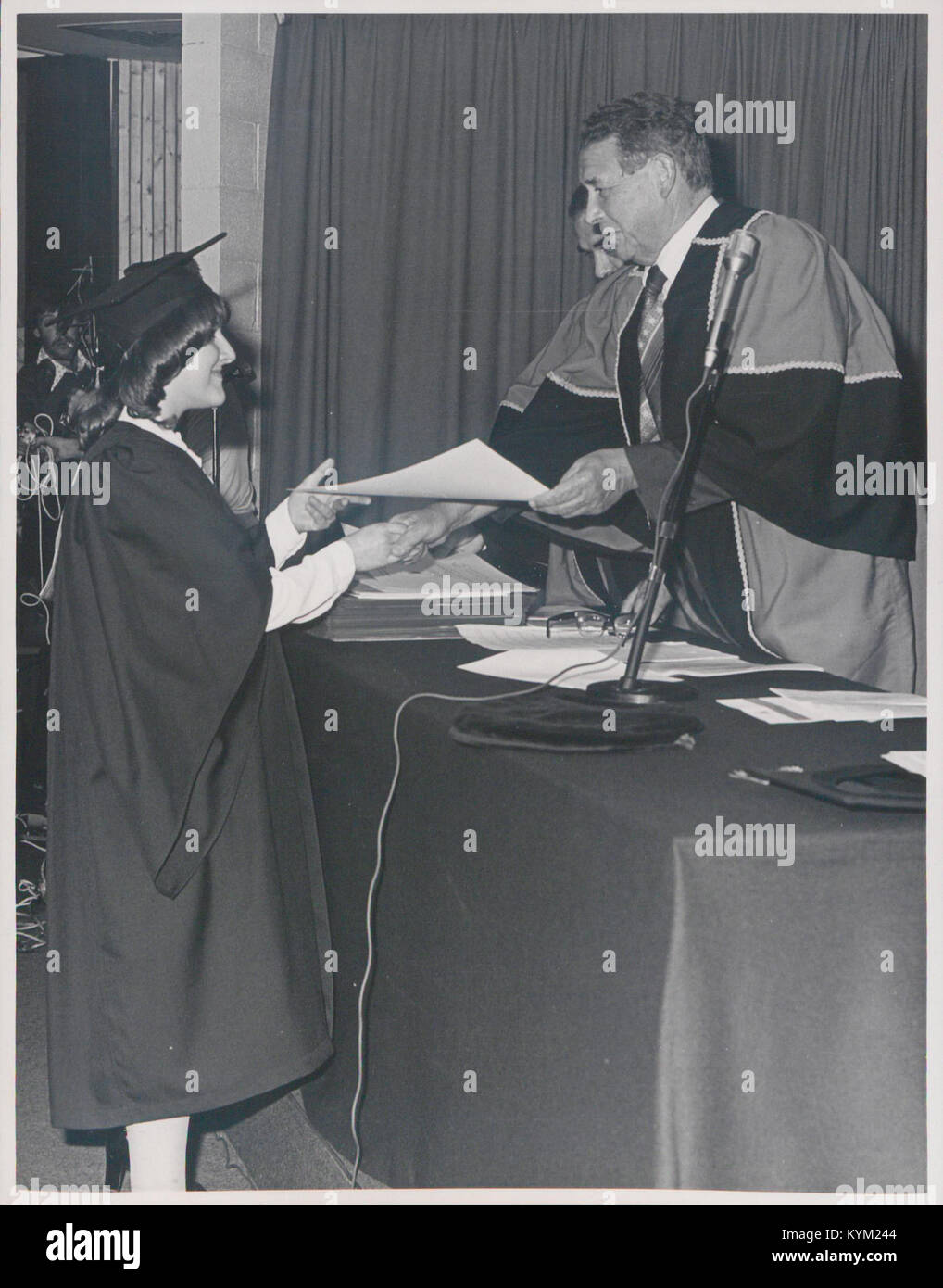 Photograph capturing a graduate receiving her diploma during a ...