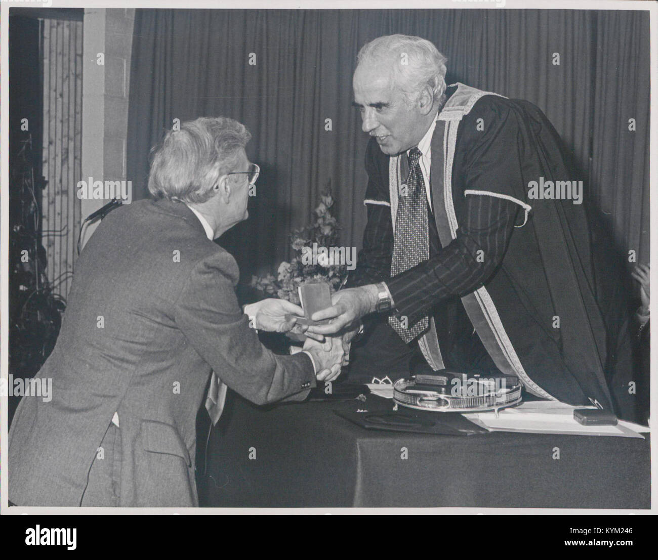 This image captures Paul Quigley presenting a medal during a graduation ...