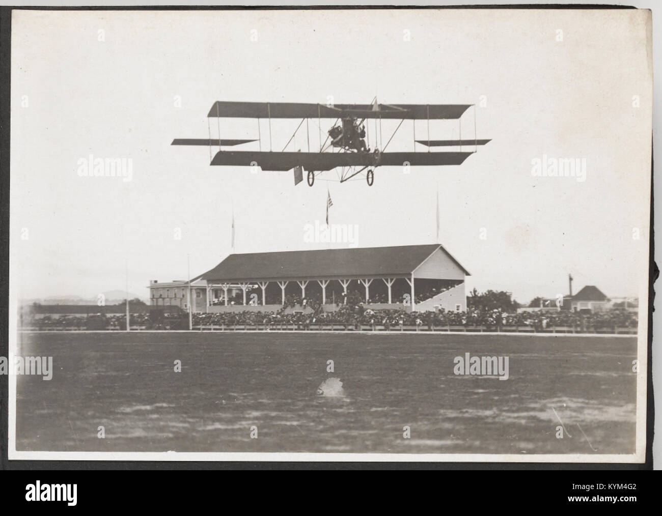 An early Curtiss Pusher aircraft in flight during an airshow, with a ...
