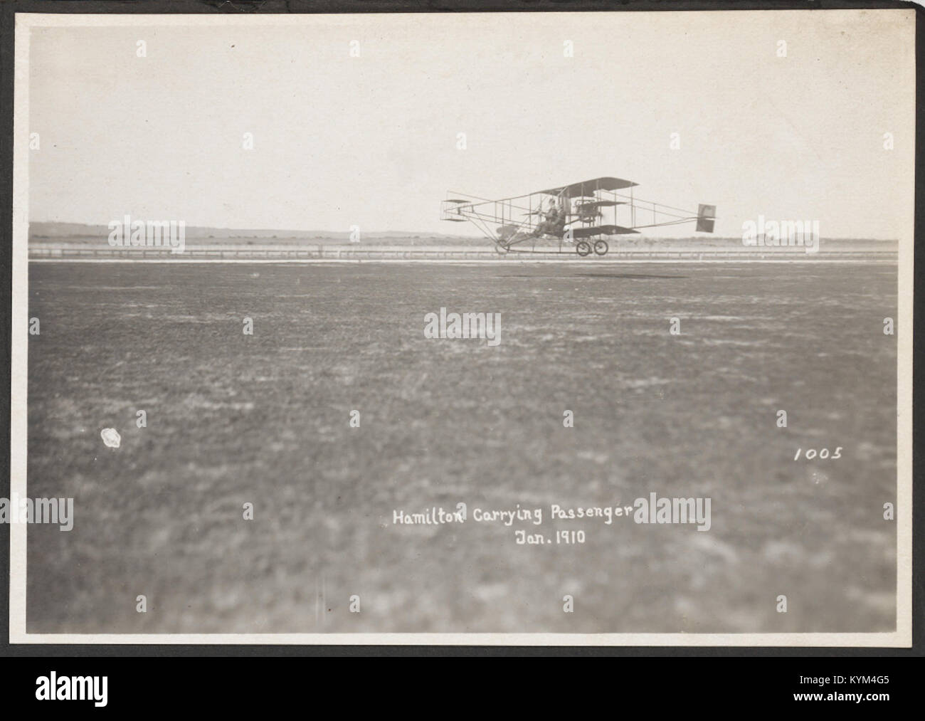 Charles Hamilton piloting an early biplane in January 1910, carrying a ...
