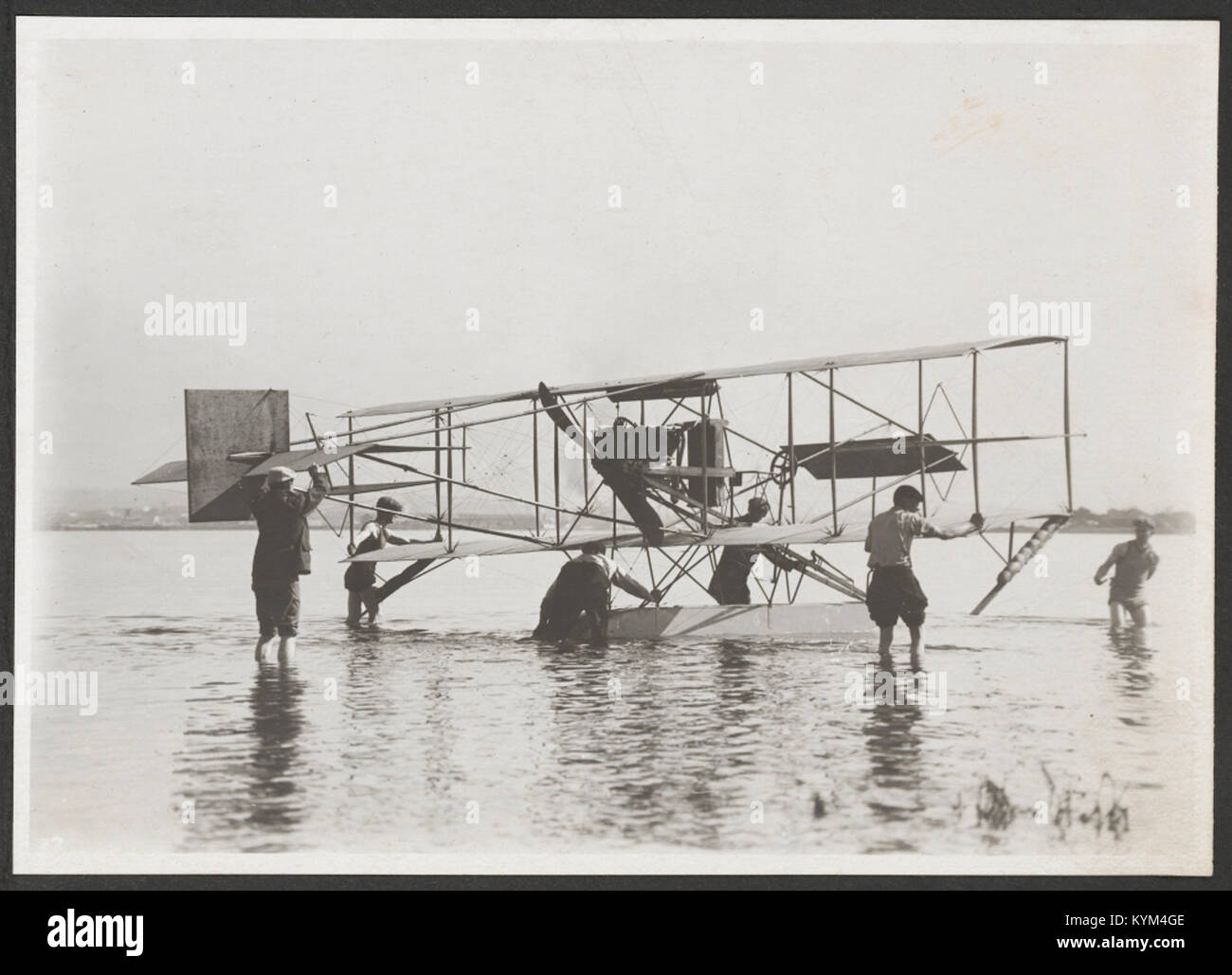 Image of crew members preparing a Curtiss Pusher biplane for takeoff ...
