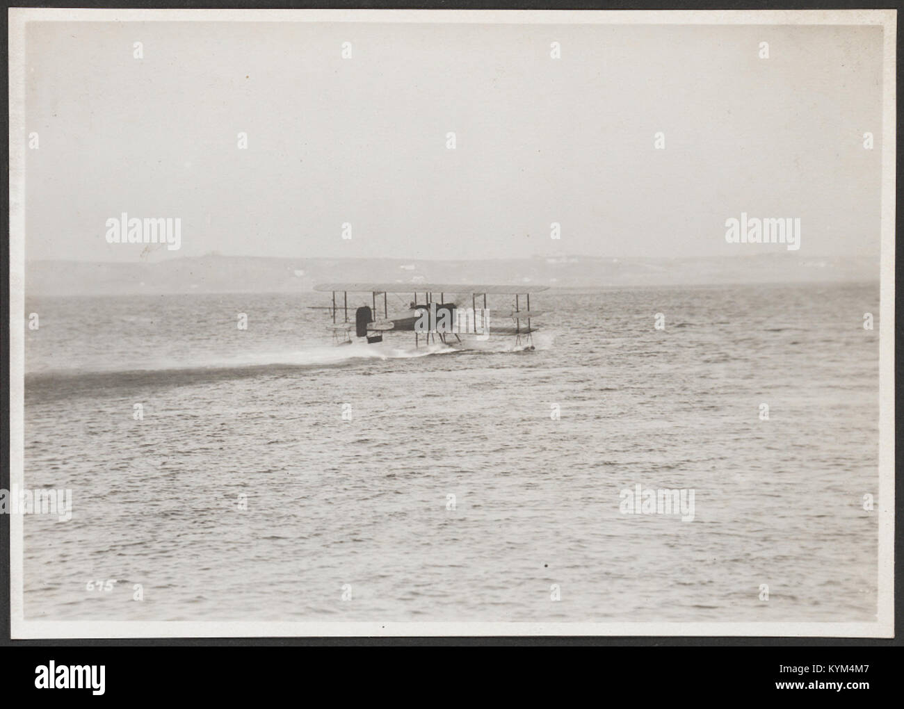This photograph shows the Martin TT biplane in flight over water ...