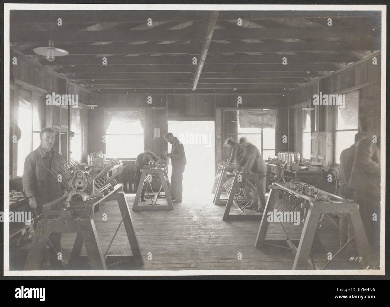 A photograph showing mechanics at work in an airplane workshop ...