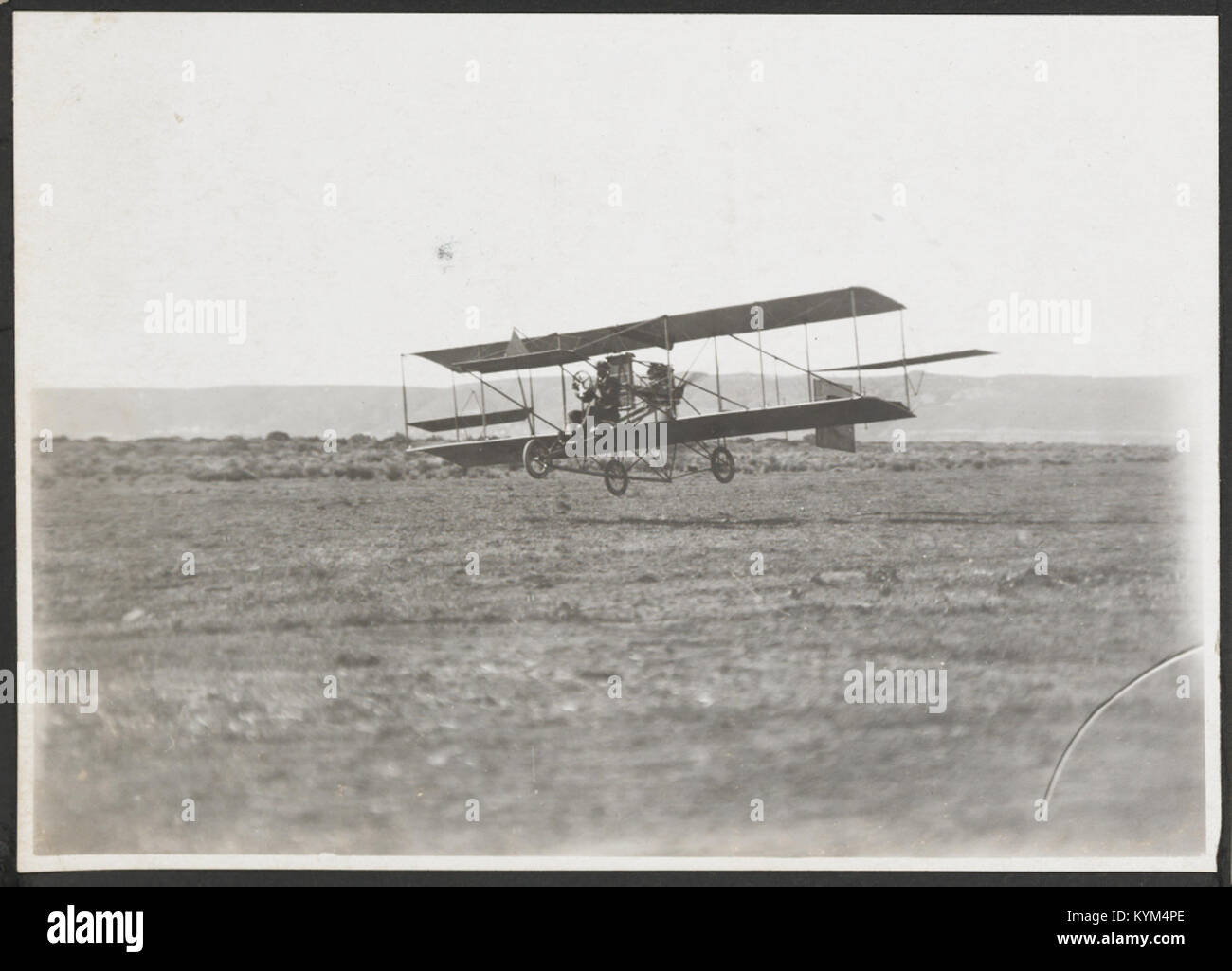 A historic photograph of a Curtiss Pusher biplane flying over the ...