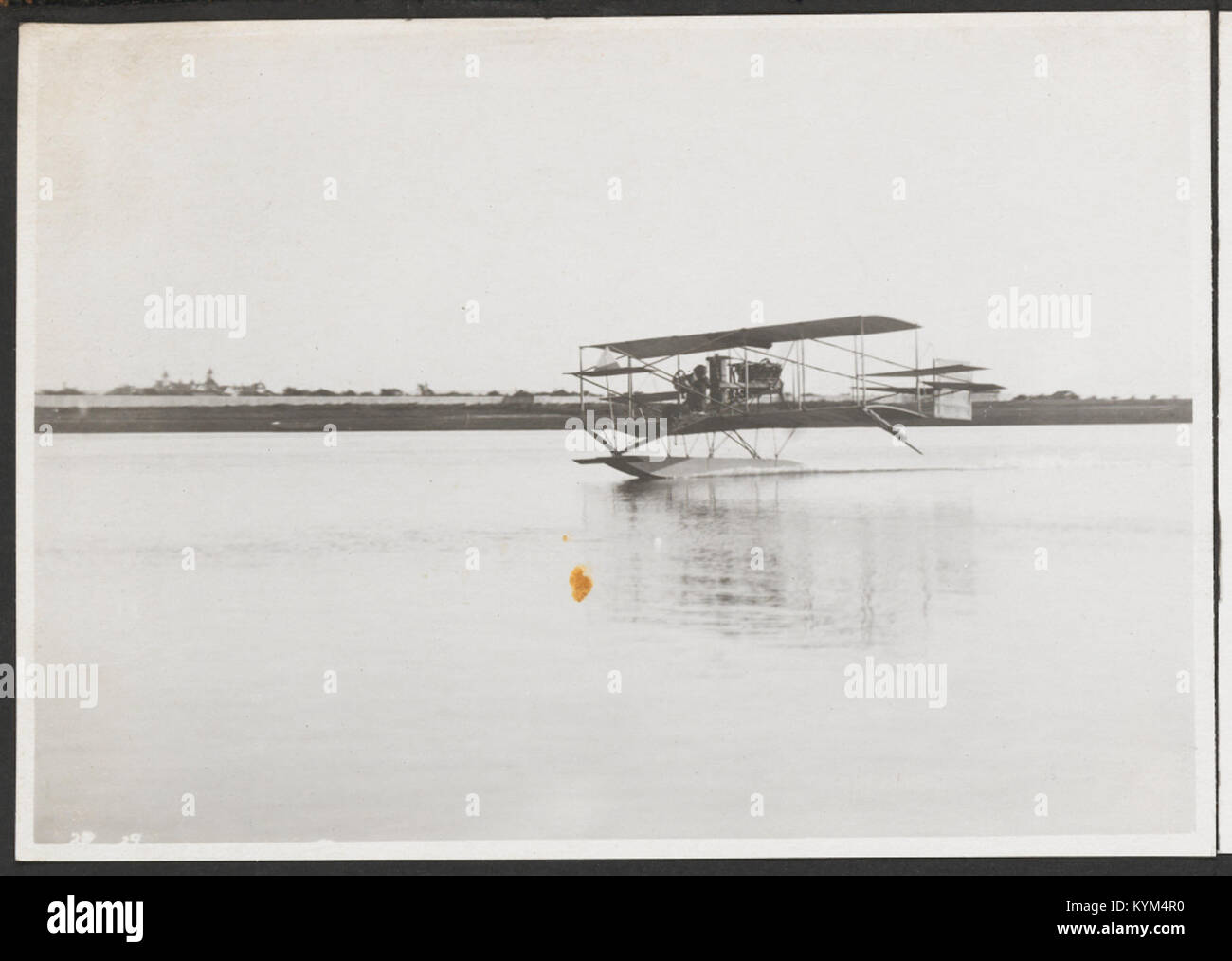 An image of Glenn Curtiss piloting a Curtiss Pusher seaplane, skimming ...