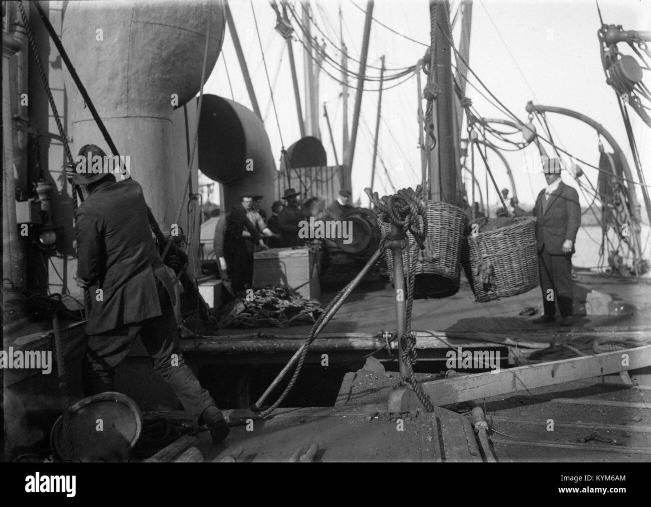 This photograph depicts free laborers working on the deck of a ship ...