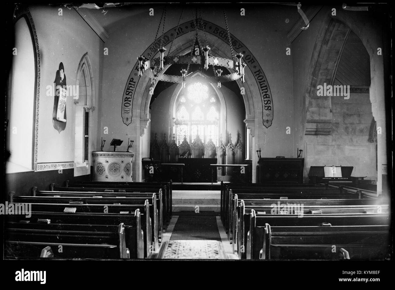 Interior view of a church featuring the altar and pews. An inscription ...
