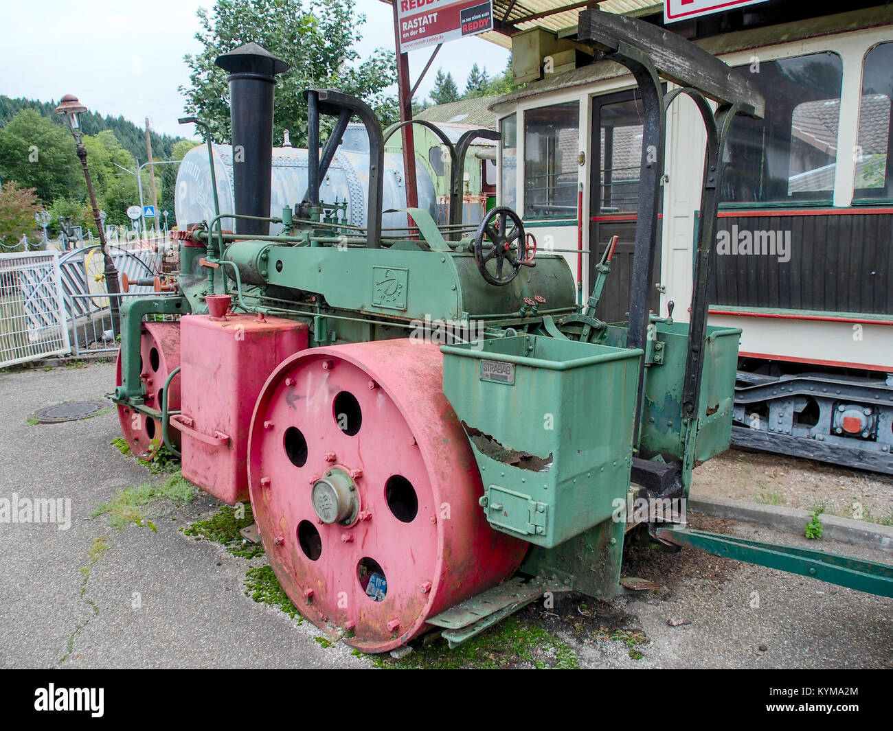 A historical photograph of a Strabag steam roller with a trailer, taken ...